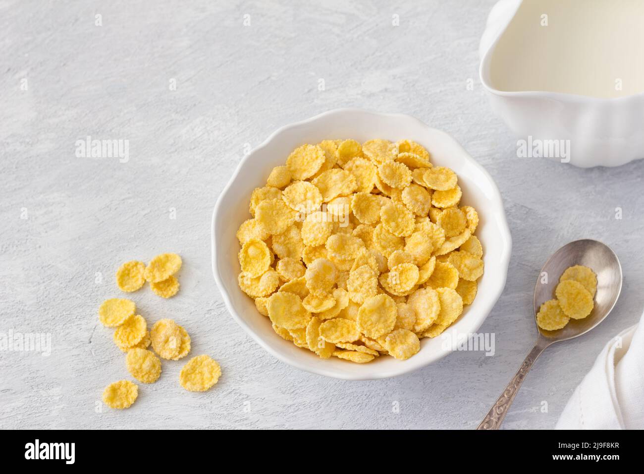 Sweet crunchy cornflakes with milk on a gray textured background. Fast ...