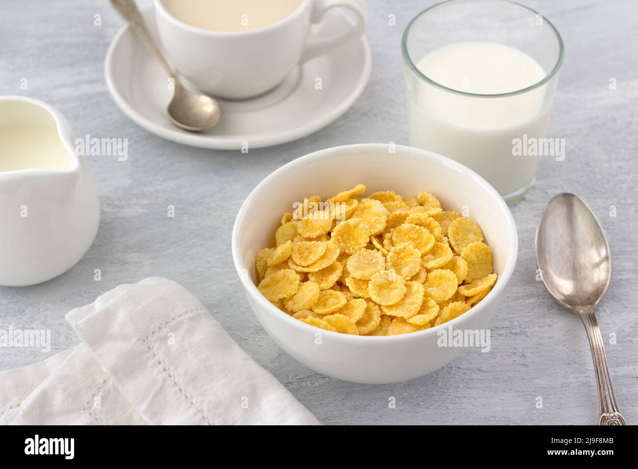 Sweet crunchy cornflakes with milk on a gray textured background. Fast ...
