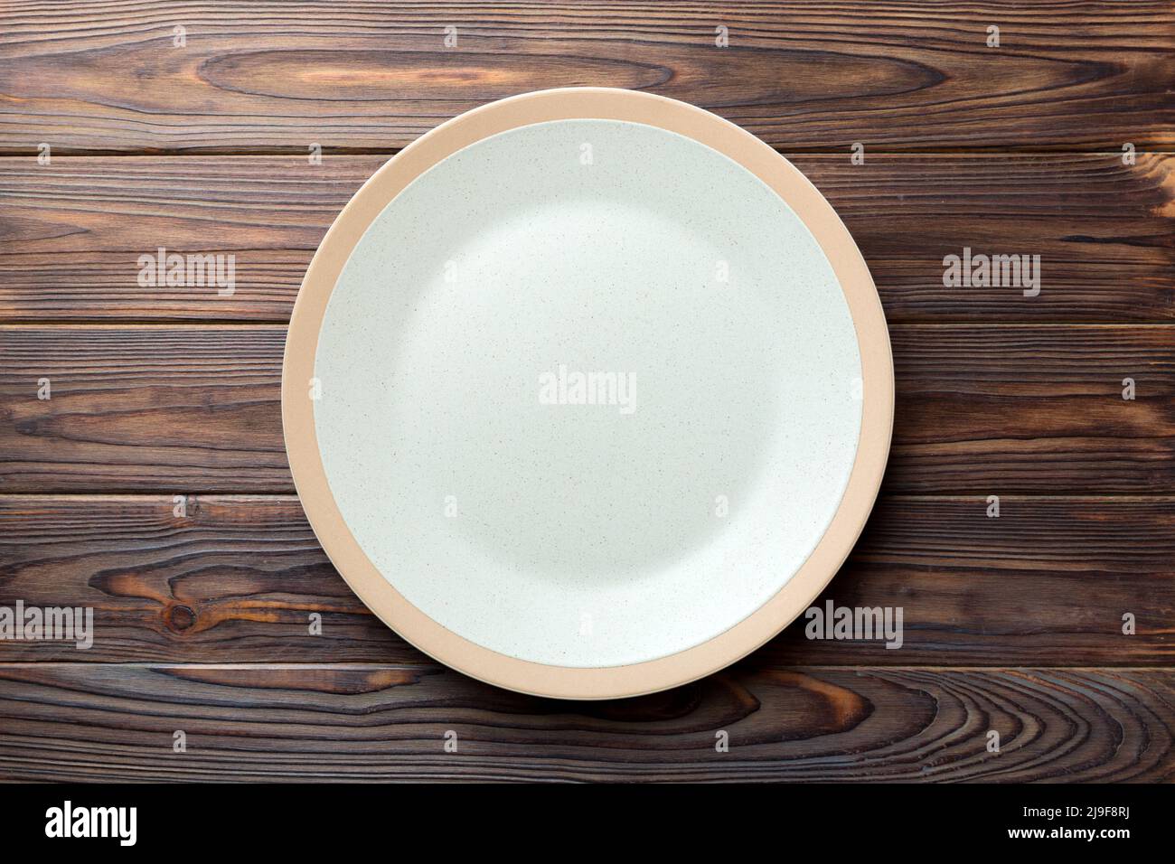 Top view of empty light plate on wooden background. Empty space for ...