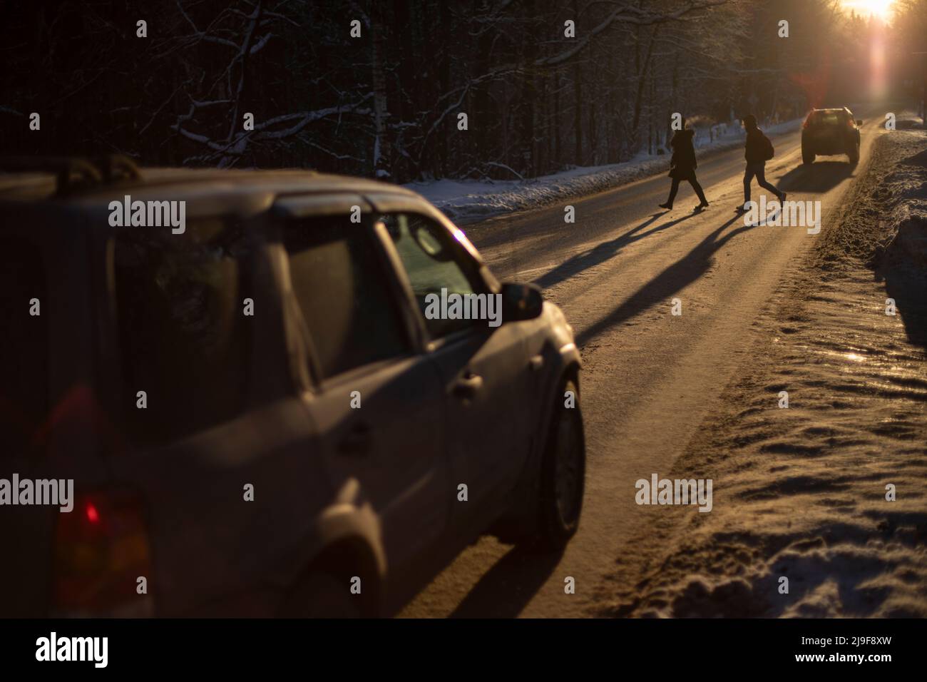 People are walking across street. Pedestrians break rules. Car is ...