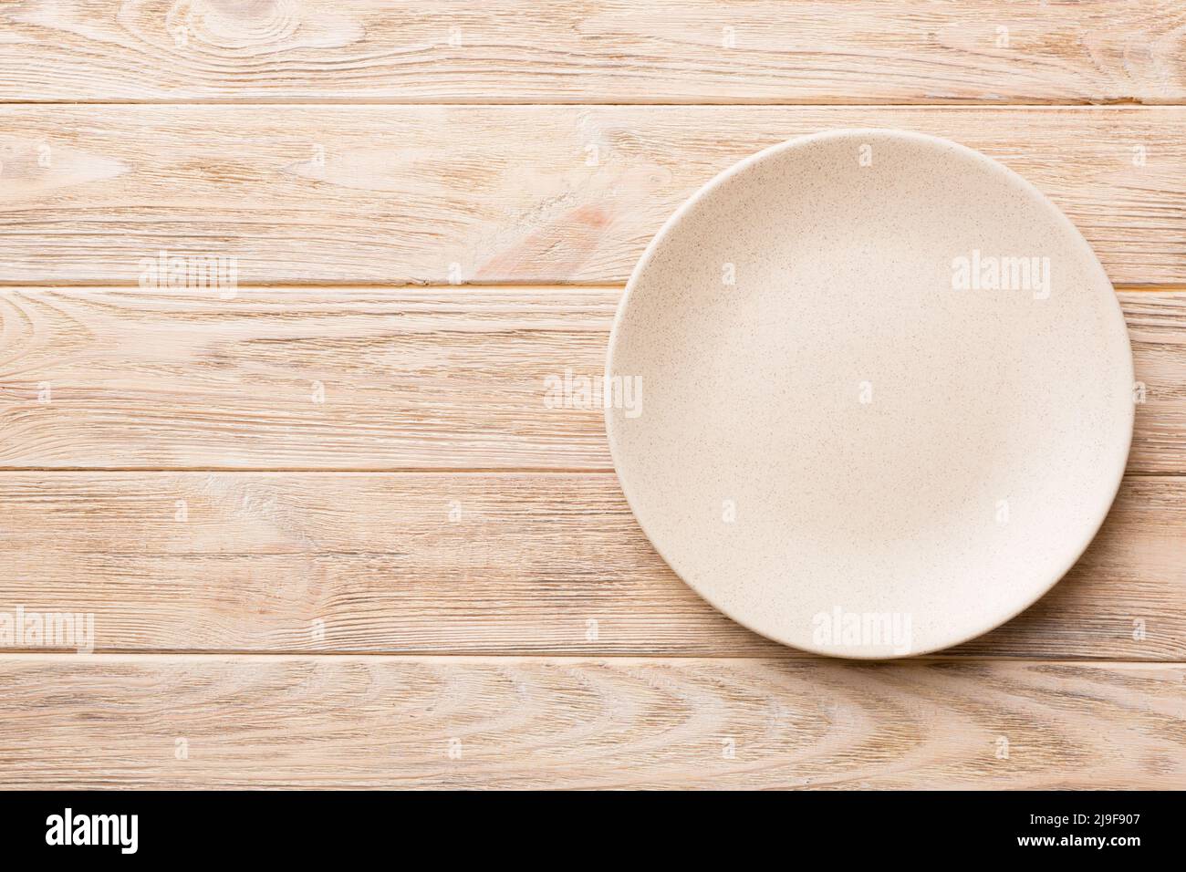 Top view of empty light plate on wooden background. Empty space for ...