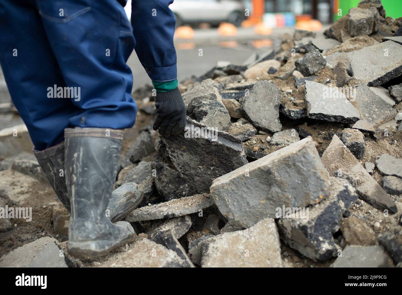 Worker carries stone. Cleaning of construction waste. Broken stone. Man ...