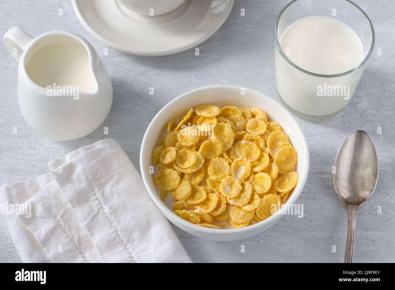 Sweet crunchy cornflakes with milk on a gray textured background. Fast ...