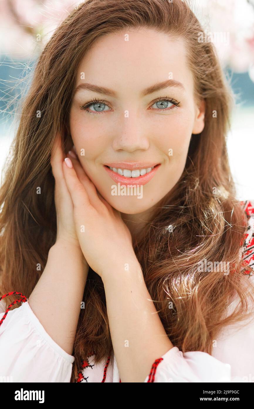 Portrait of a beautiful European woman in the spring park. Sakura ...