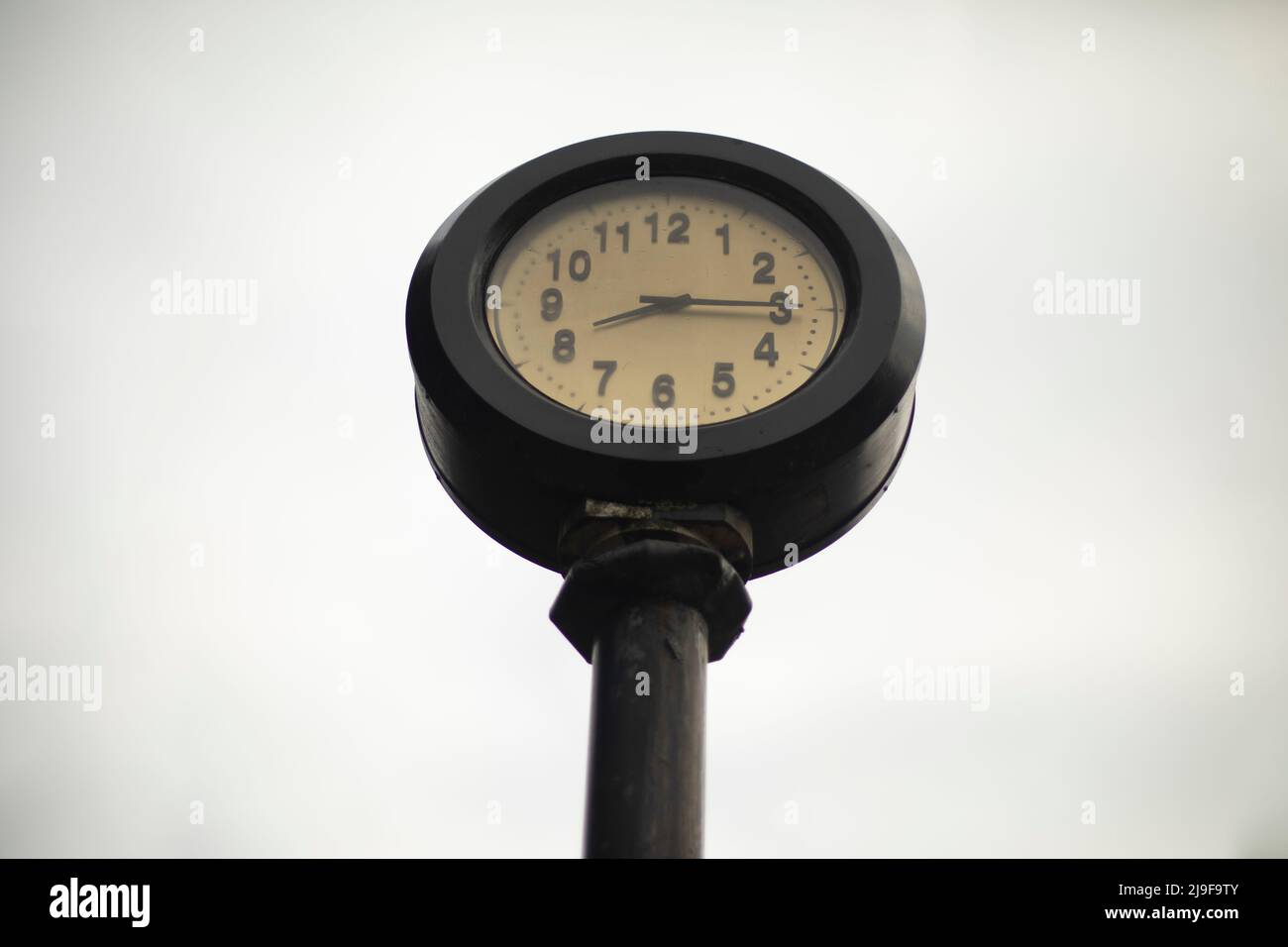 Post clock. Glittering clock against sky. Dial is outside. Waiting time ...