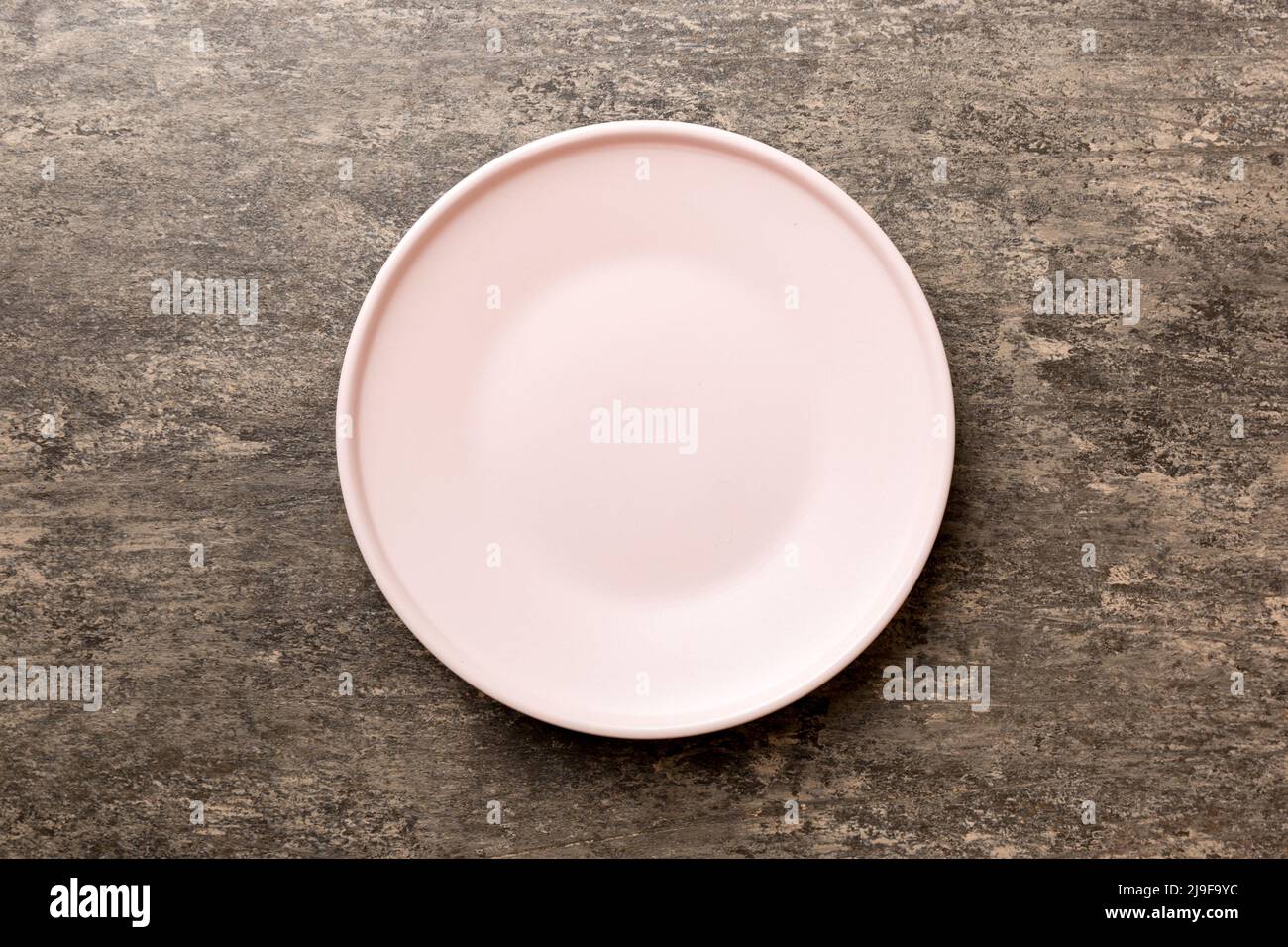 Top view of empty pink plate on cement background. Empty space for your ...