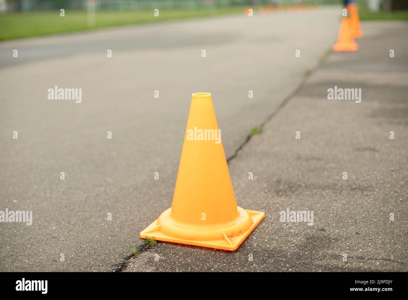 Orange cap on road. Warning sign. Direction limiter Stock Photo - Alamy