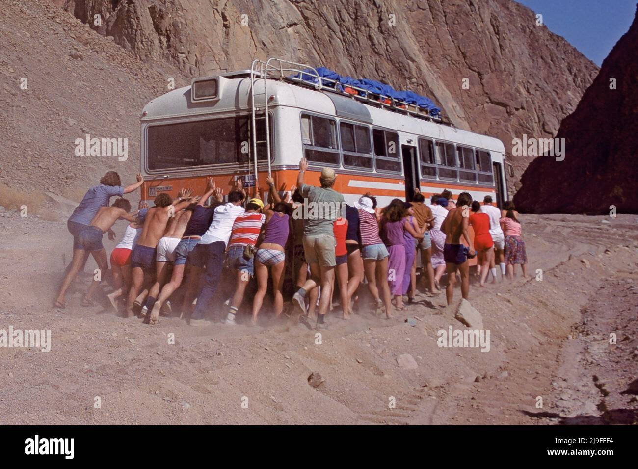 People pushing bus from behind through desert Stock Photo - Alamy