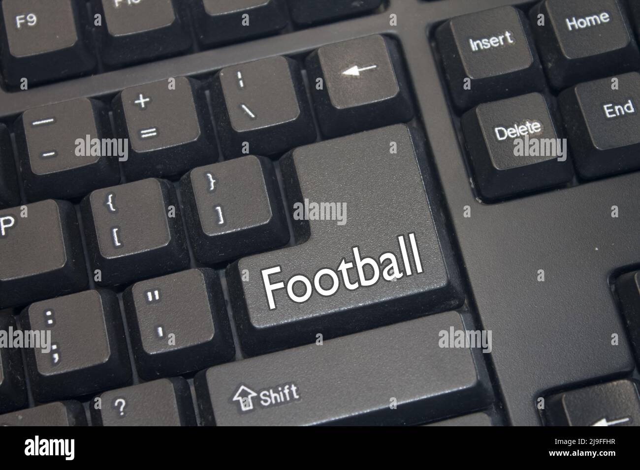 Black Computer Keyboard with Football text. Close-up of an electronic ...