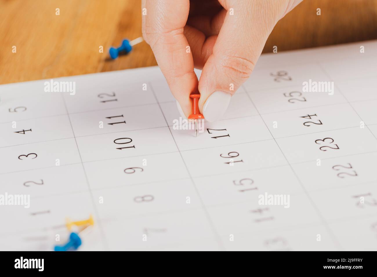 red Hand pin stuck on the day of the month in the calendar, business ...