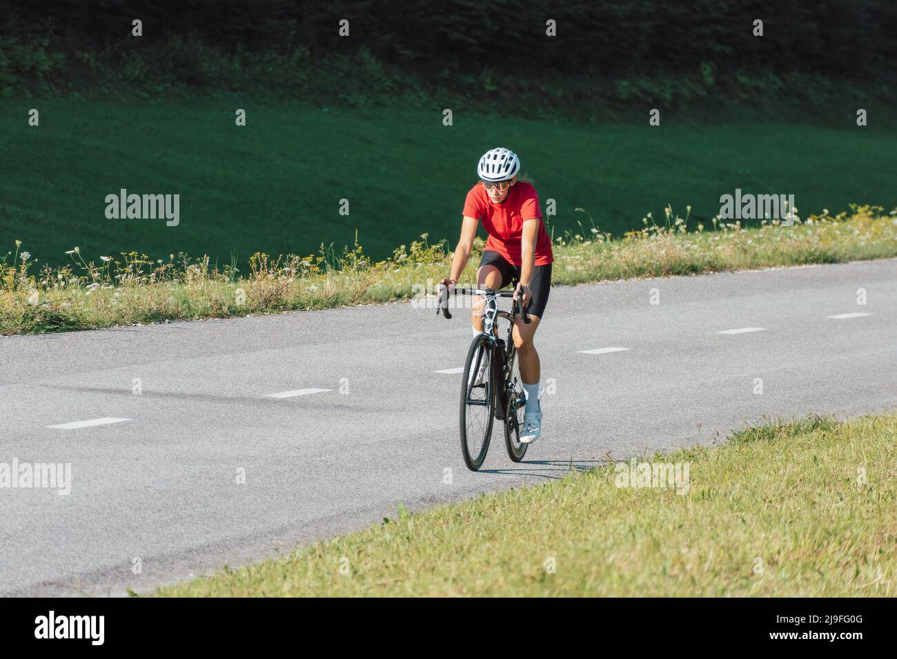 Caucasian girl cyclist with professional racing sports gear riding on ...