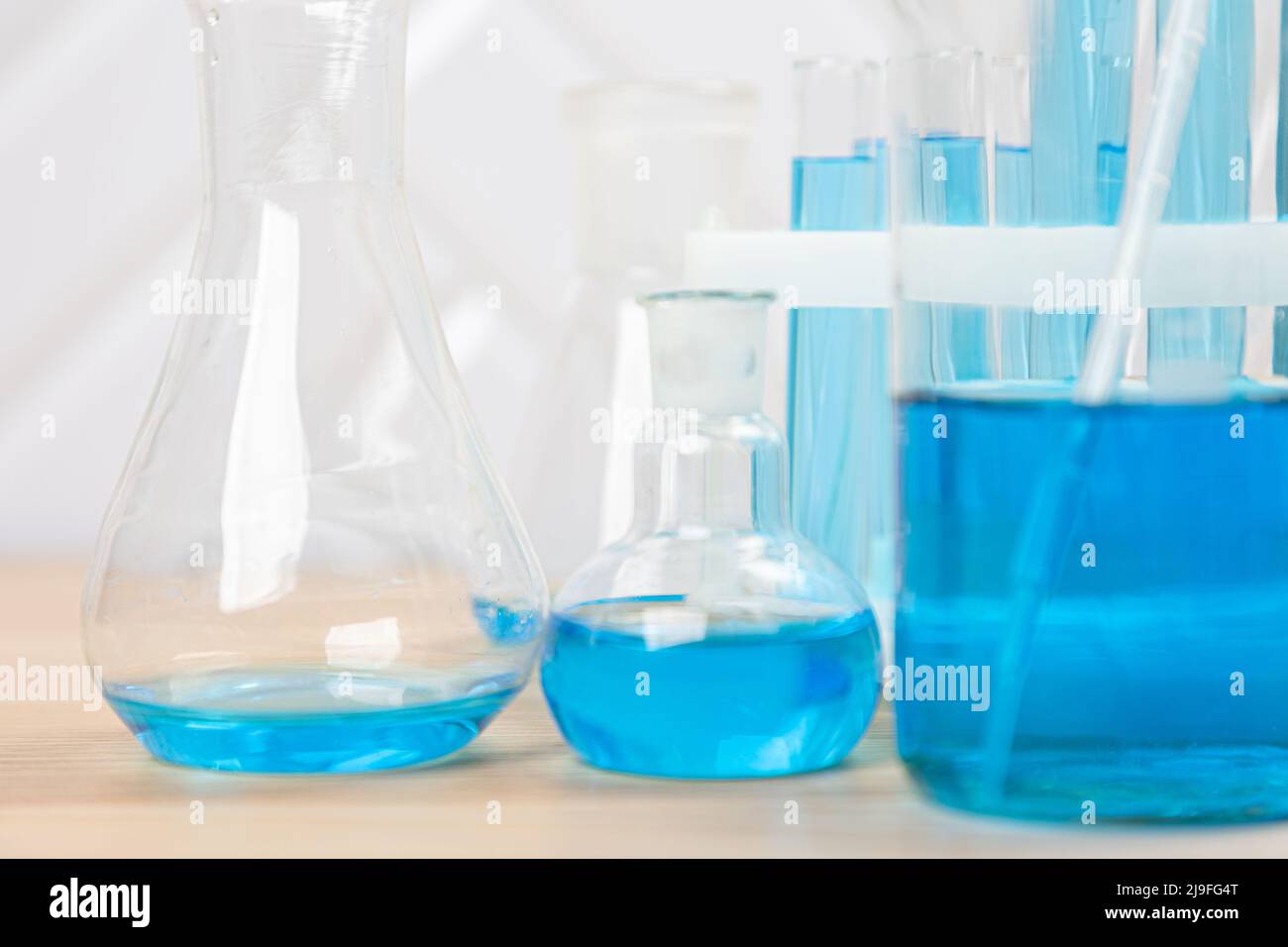 Laboratory glassware with blue liquid in a test tube. scientific ...