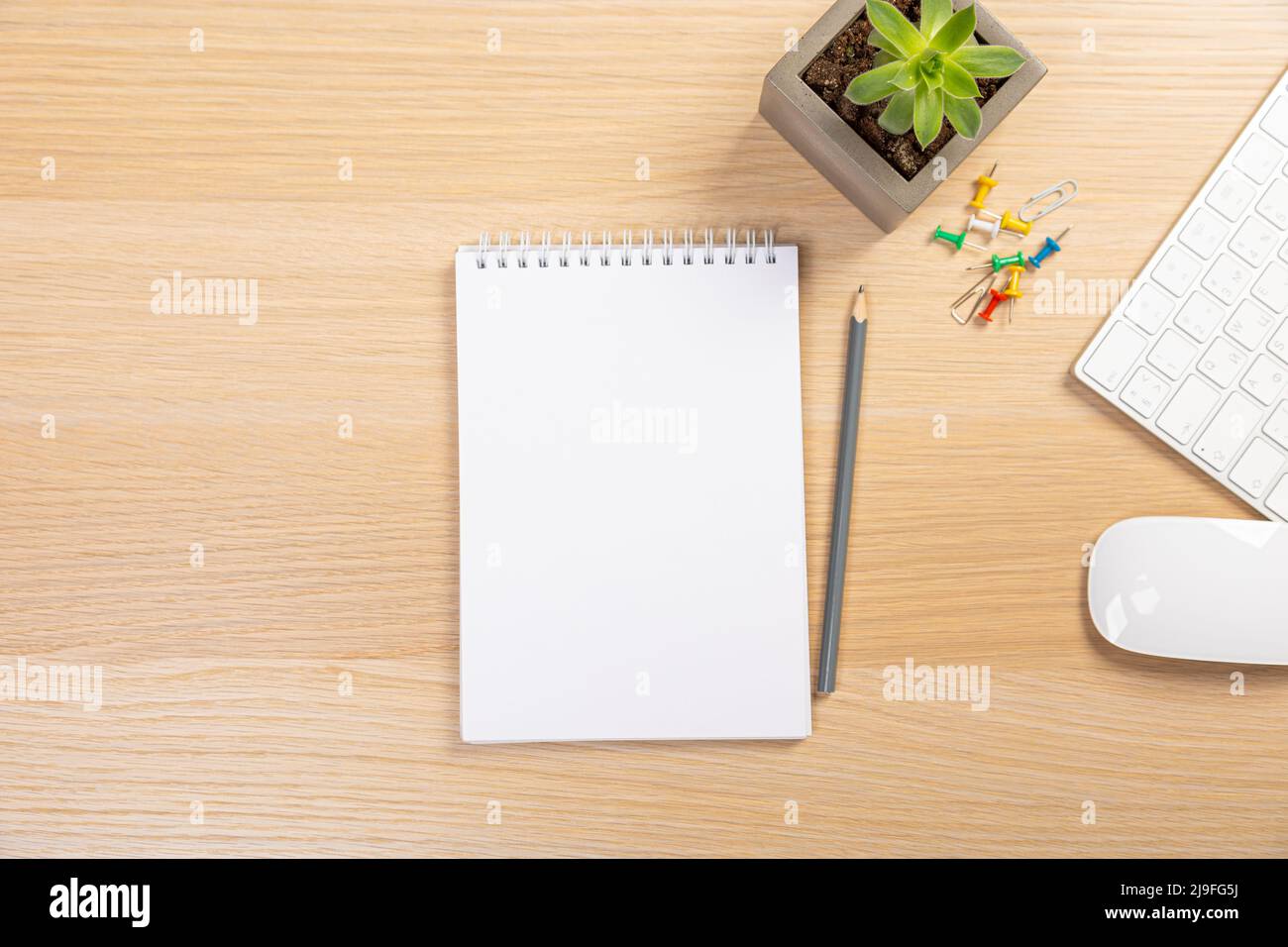 Working table with keyboard and notepad, pen, pencil and plant in home ...