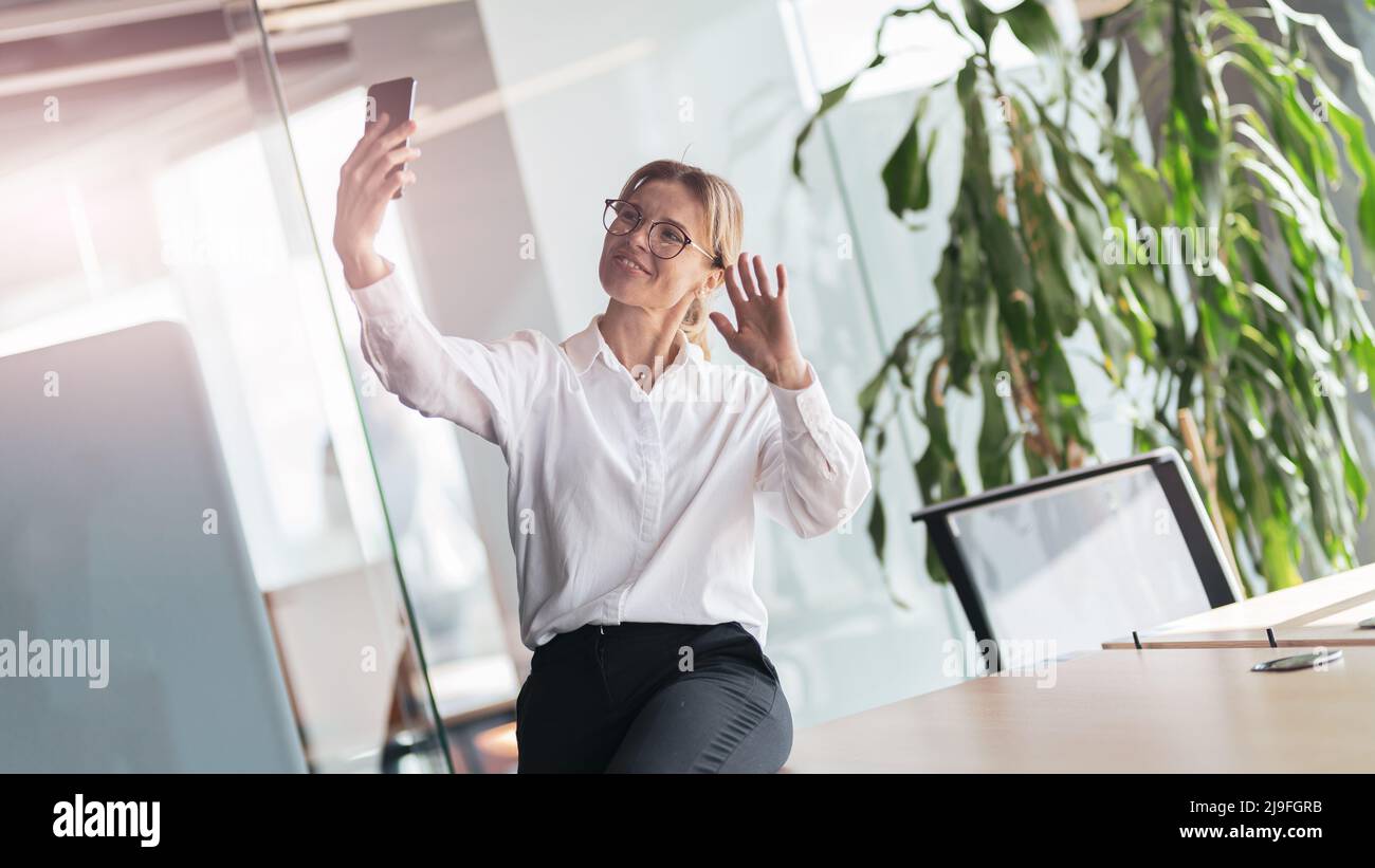 Business Woman making video call to her colleague during break time ...