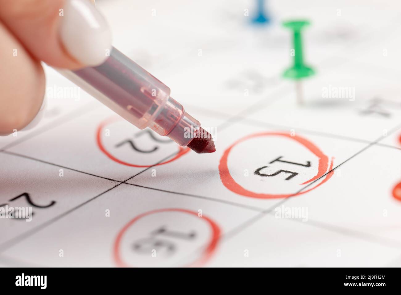 female hand marks with a red marker in the calendar notes an important ...