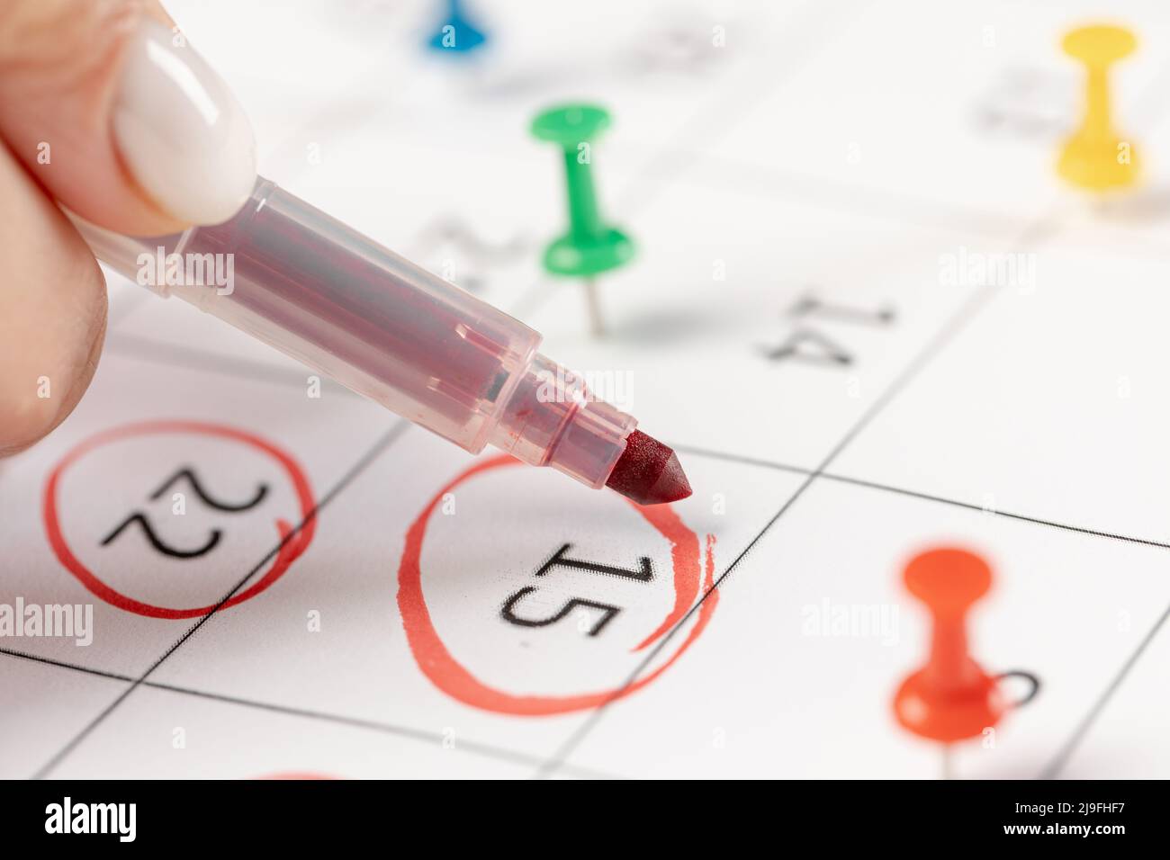 female hand marks with a red marker in the calendar notes an important ...