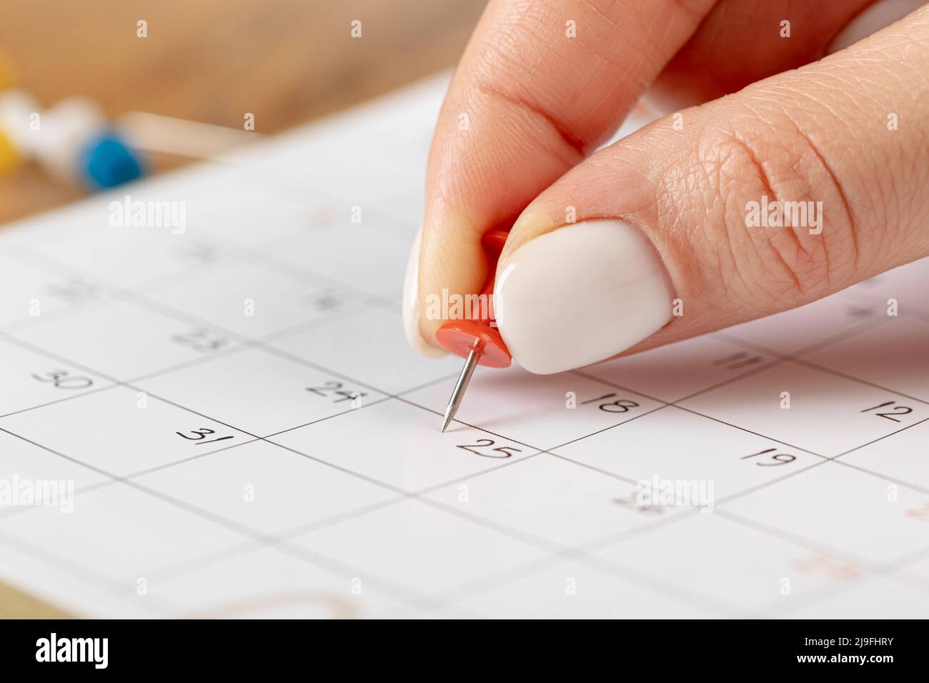 red Hand pin stuck on the day of the month in the calendar, business ...