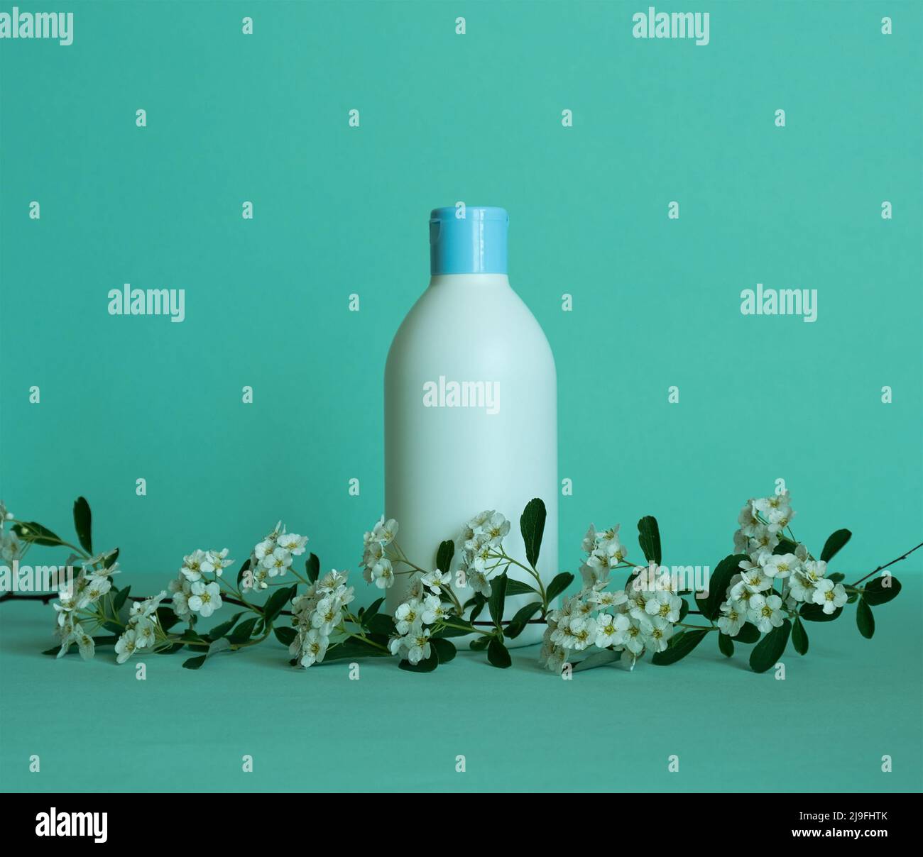 A bottle for cosmetic products without a label with a flower branch at ...