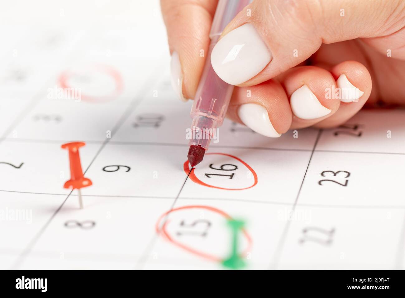 female hand marks with a red marker in the calendar notes an important ...