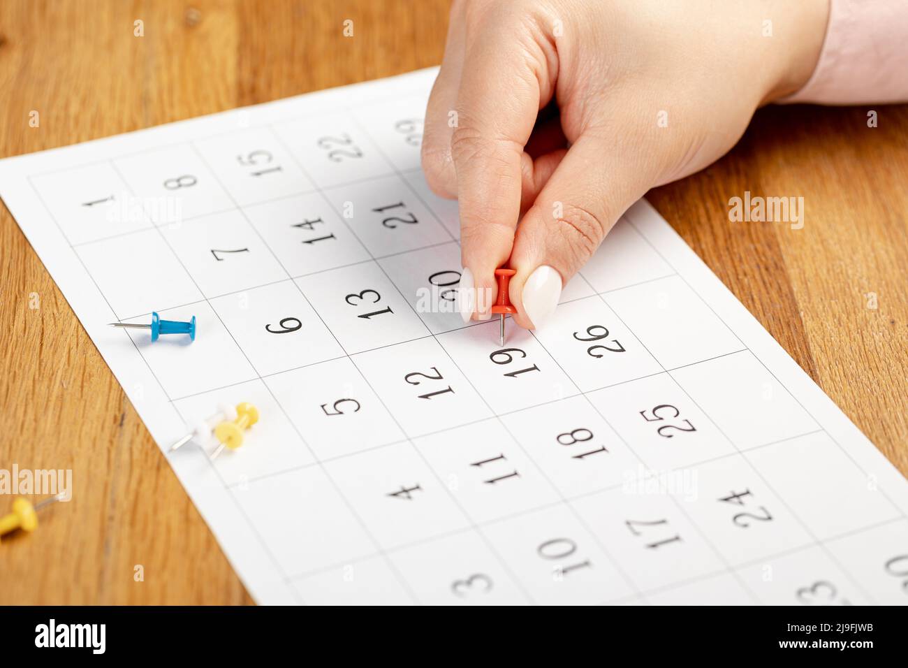 red Hand pin stuck on the day of the month in the calendar, business ...
