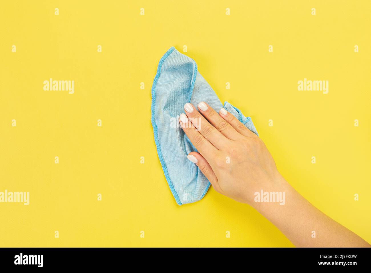 A housewife's hand holds a rag for dusting or washing. Empty space for ...