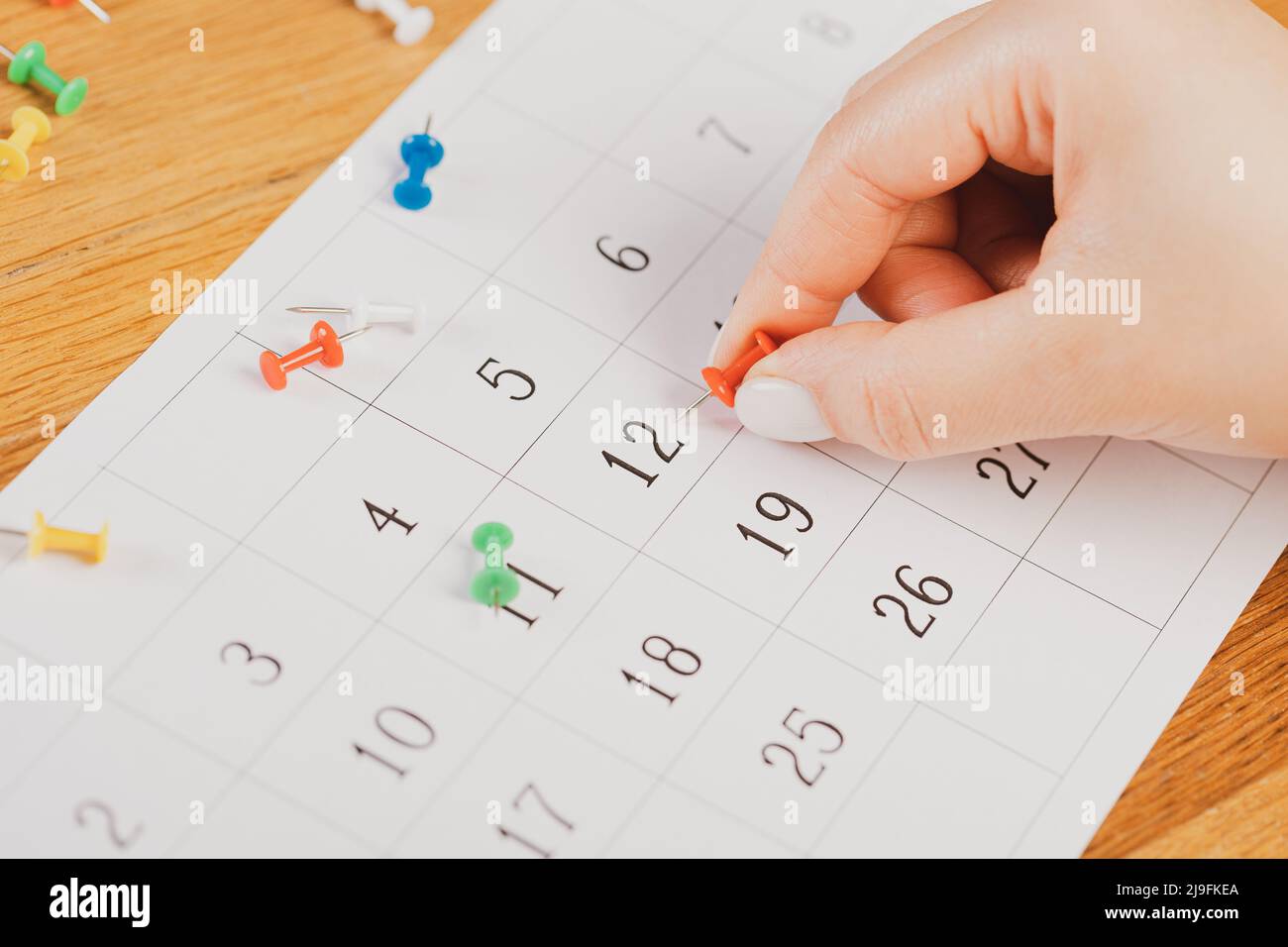 red Hand pin stuck on the day of the month in the calendar, business ...