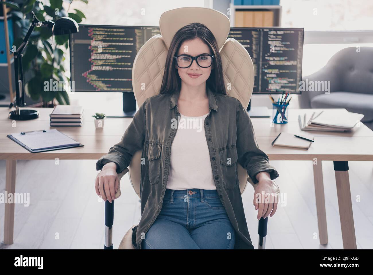 Portrait of attractive cheerful skilled girl sitting in chair ...