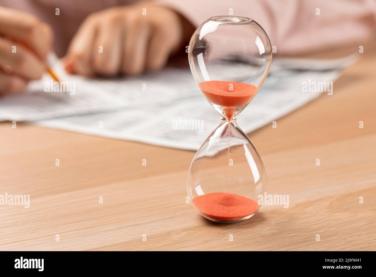 Hourglass with time running out and student hand testing in exercise ...