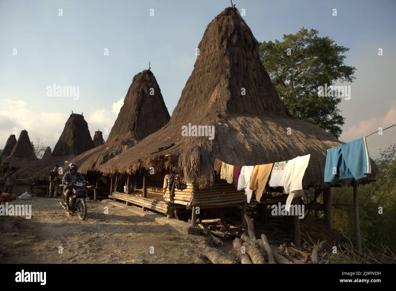A motorist riding in front of traditional houses in traditional village ...