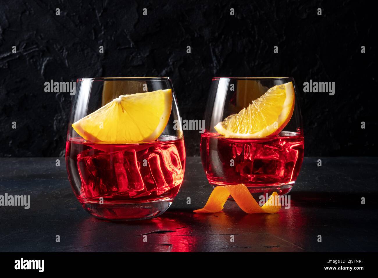 Campari aperitif with fresh orange slices, on a black background. An ...