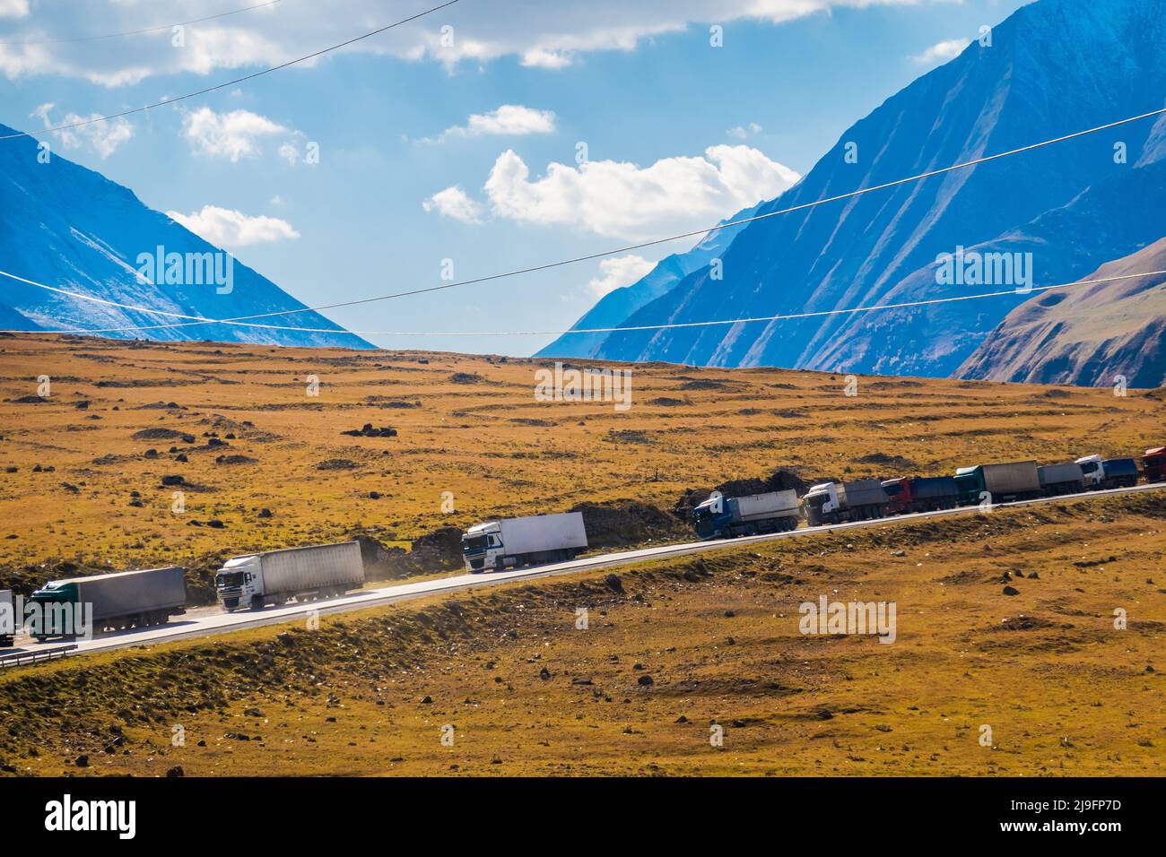 Trucks driving in valley near mountains Stock Photo - Alamy
