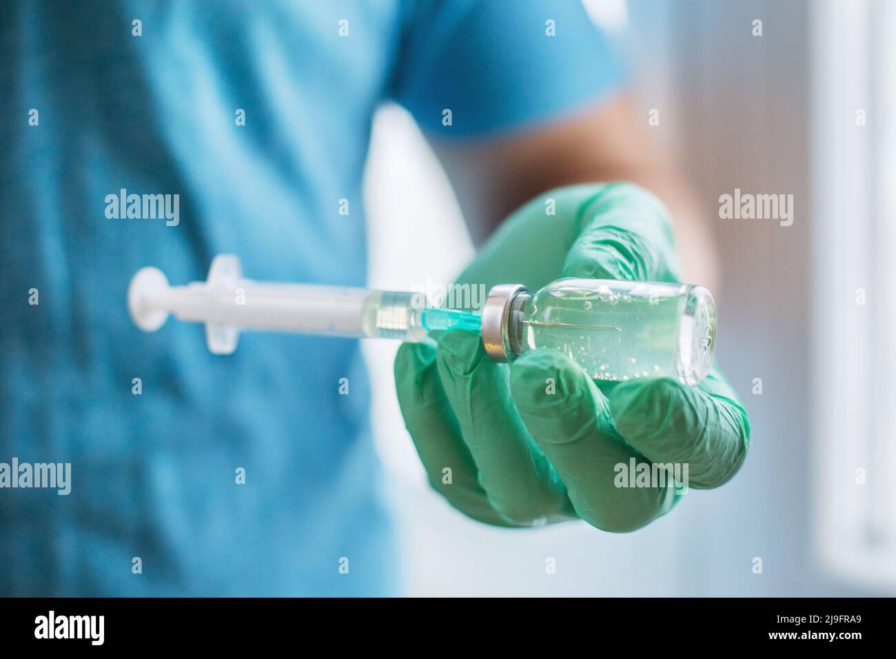 Hands of the doctor filling a syringe. Man hands in blue gloves holding ...
