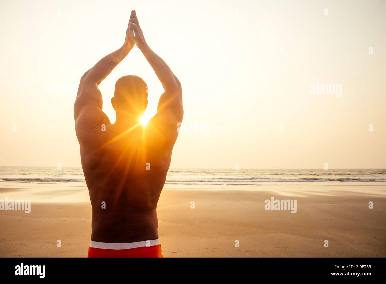 Man standing in yoga pose on ocean sunset paradise beach.Apollo ...