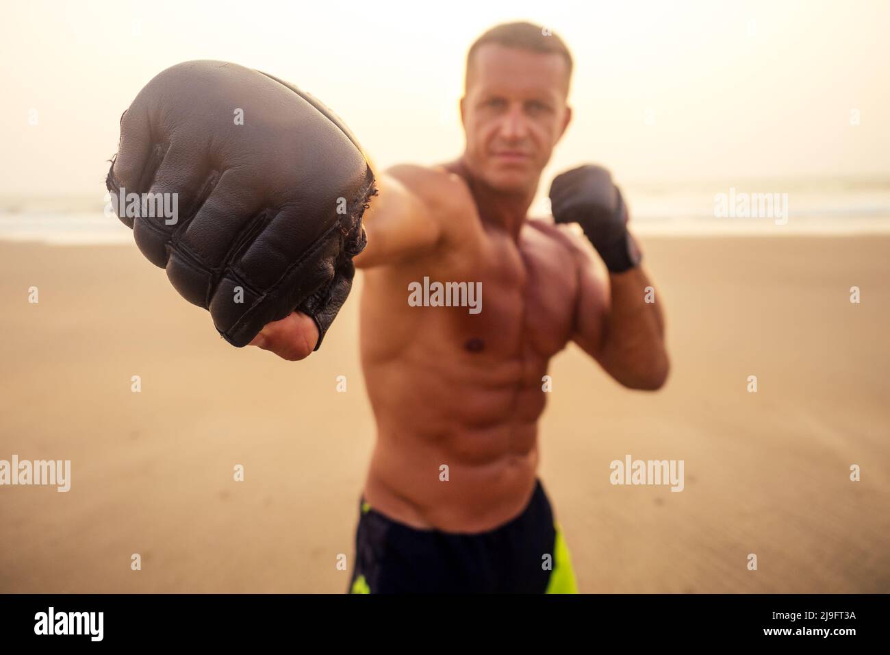 Strong boxer man doing during kickboxing exercise fight with trainer at ...
