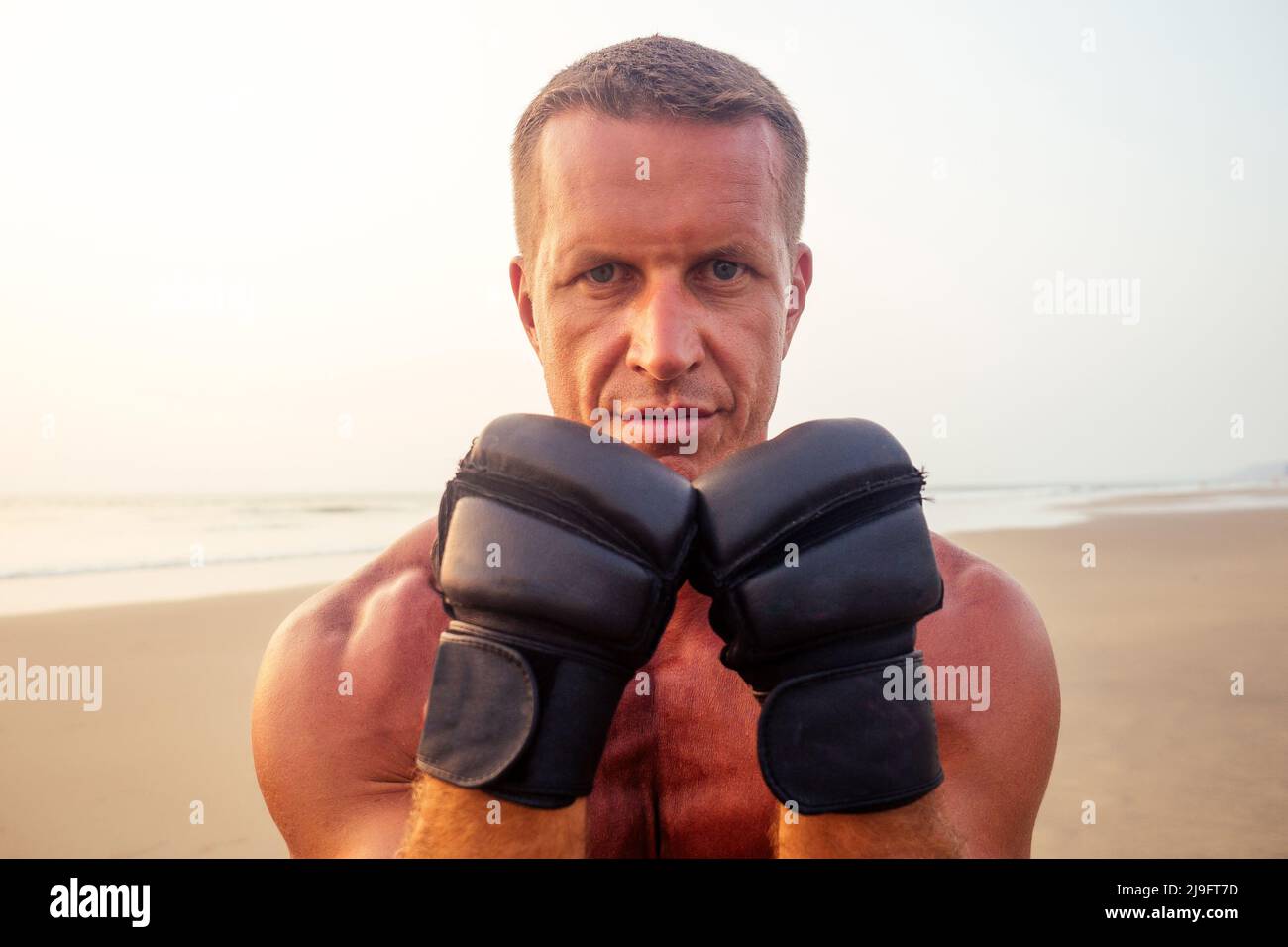 Strong boxer man doing during kickboxing exercise fight with trainer at ...