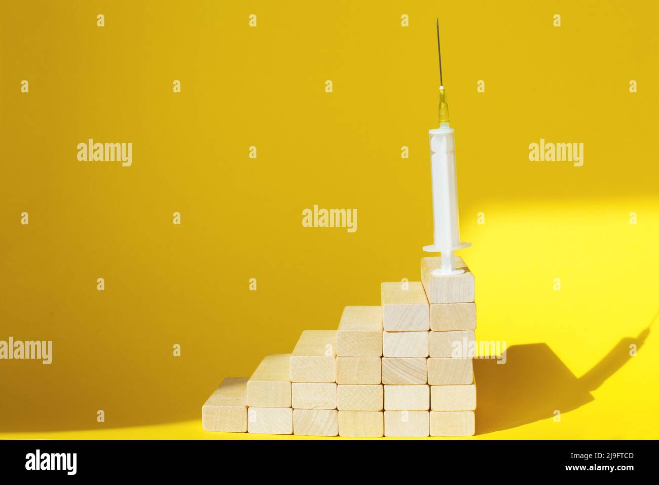 medical syringe on a ladder made of wooden sticks. drugs, vaccination ...