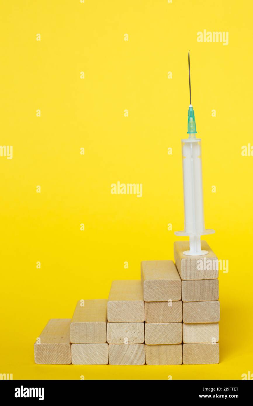 medical syringe on a ladder made of wooden sticks. drugs, vaccination ...