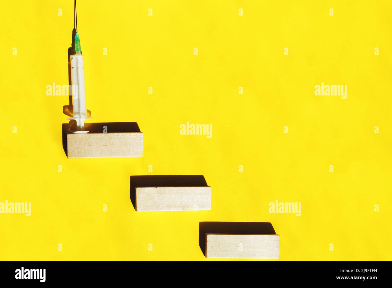 medical syringe on a ladder made of wooden sticks. drugs, vaccination ...