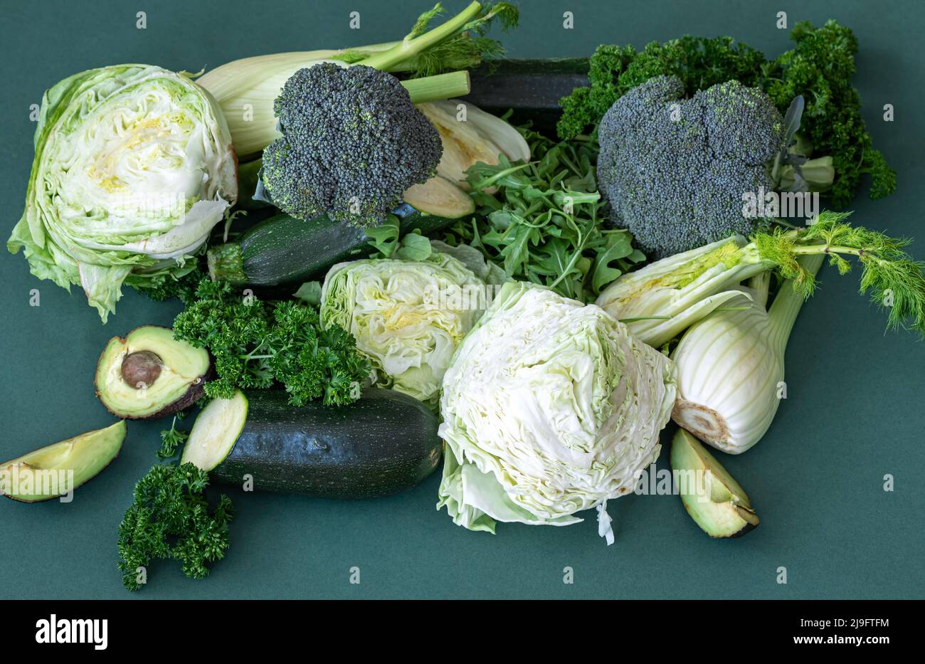 Fresh vegetables and greens on a green background Stock Photo - Alamy