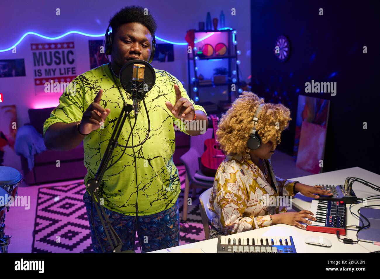 Modern gen Z African American man rapping while recording song in home ...