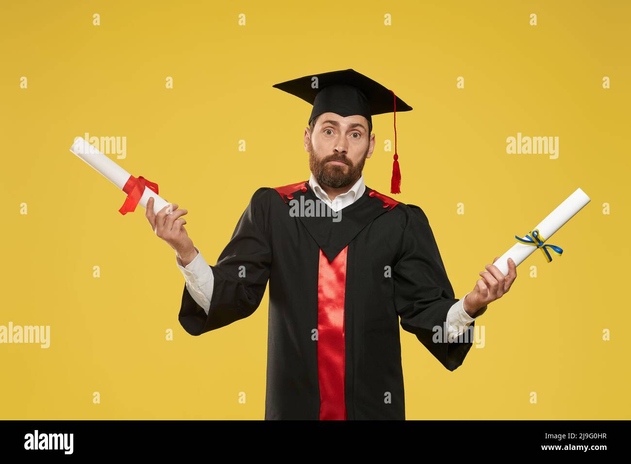 Front view of male student holding two diplomas, standing mixed up. Man ...