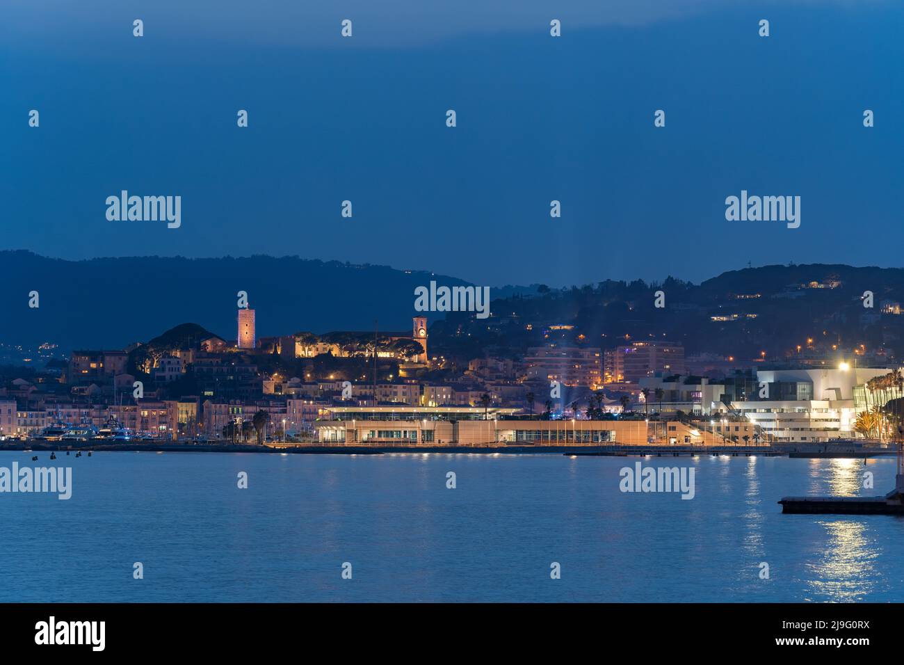 View of sea port in Cannes,France and its old town during the blue hour ...