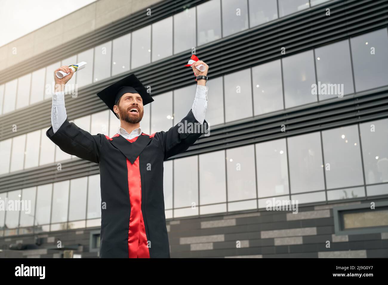 Front view of happy student graduating from college, university. Boy ...