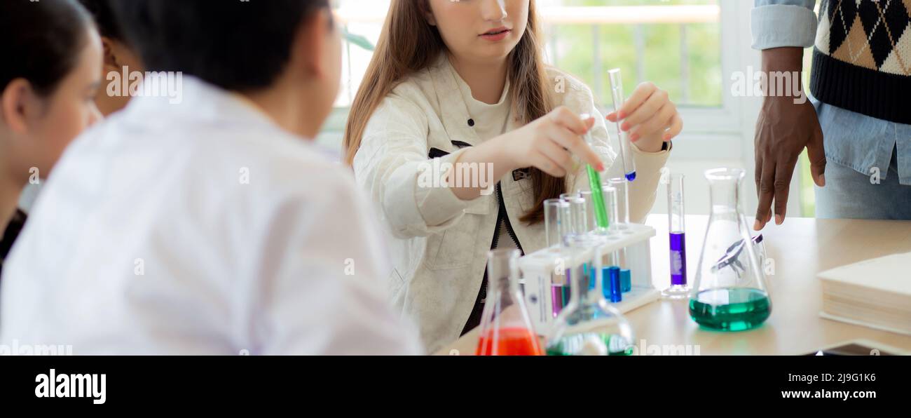 Young teacher teaching group student about science and test chemical ...