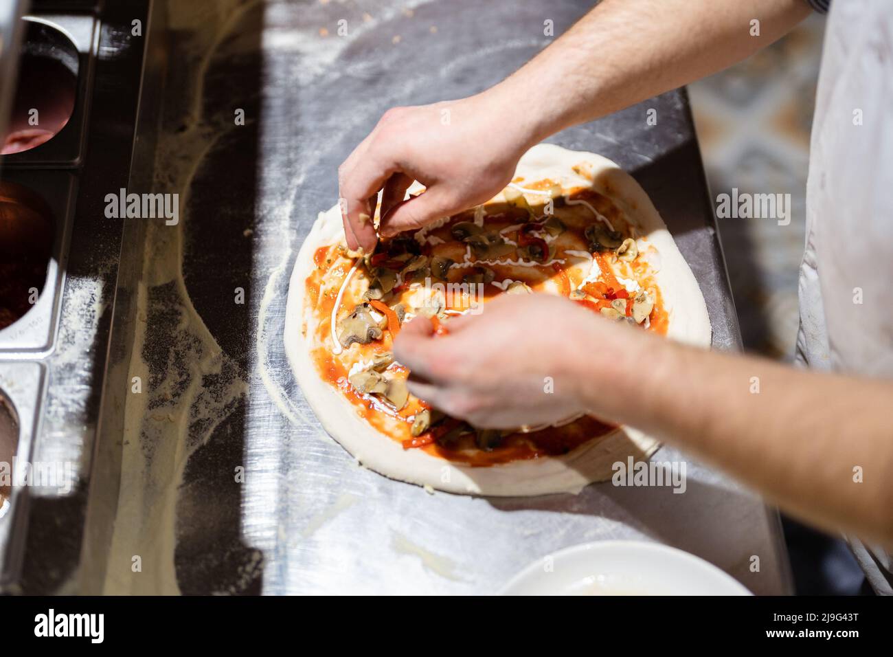 Pizza making process. Male chef hands making authentic pizza in the ...