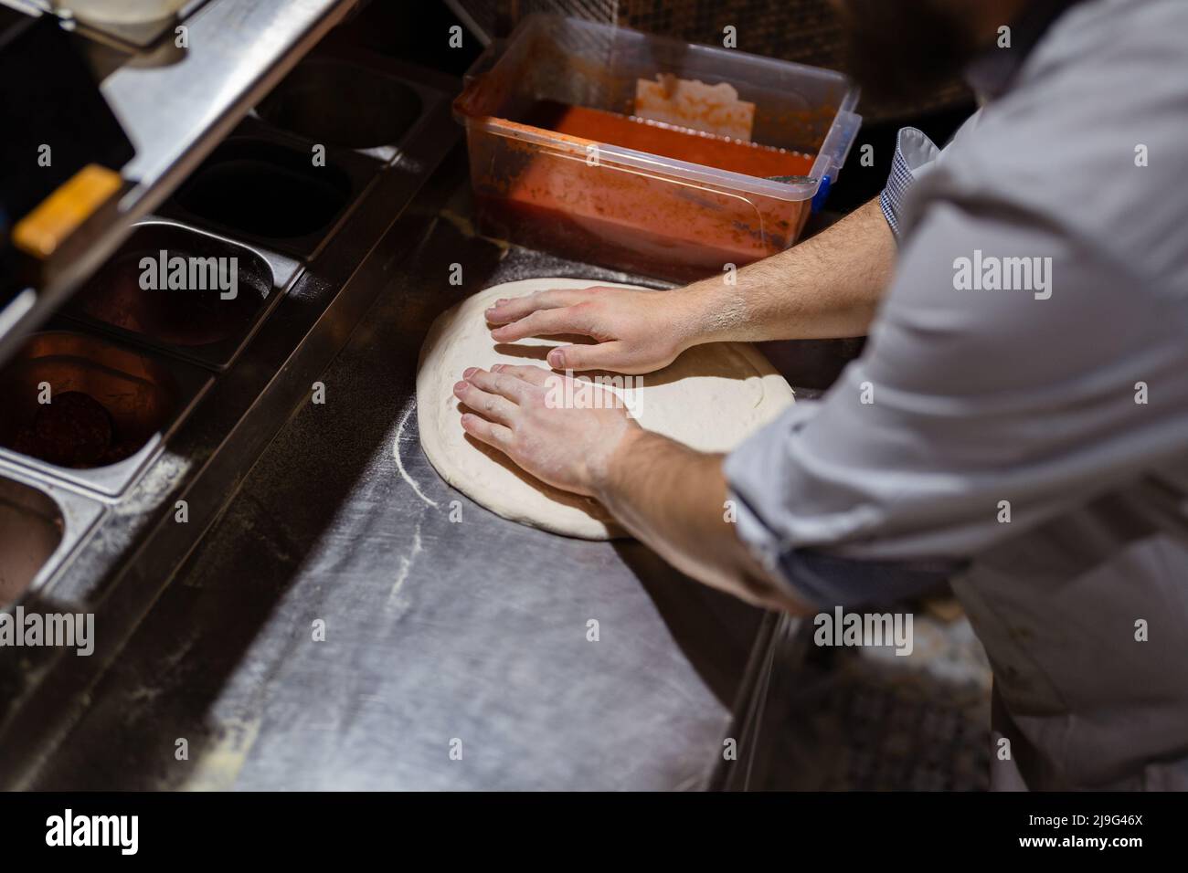Pizza making process. Male chef hands making authentic pizza in the ...