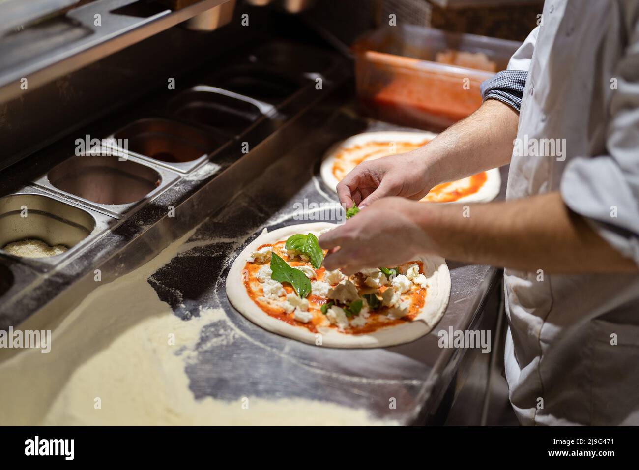 Pizza making process. Male chef hands making authentic pizza in the ...