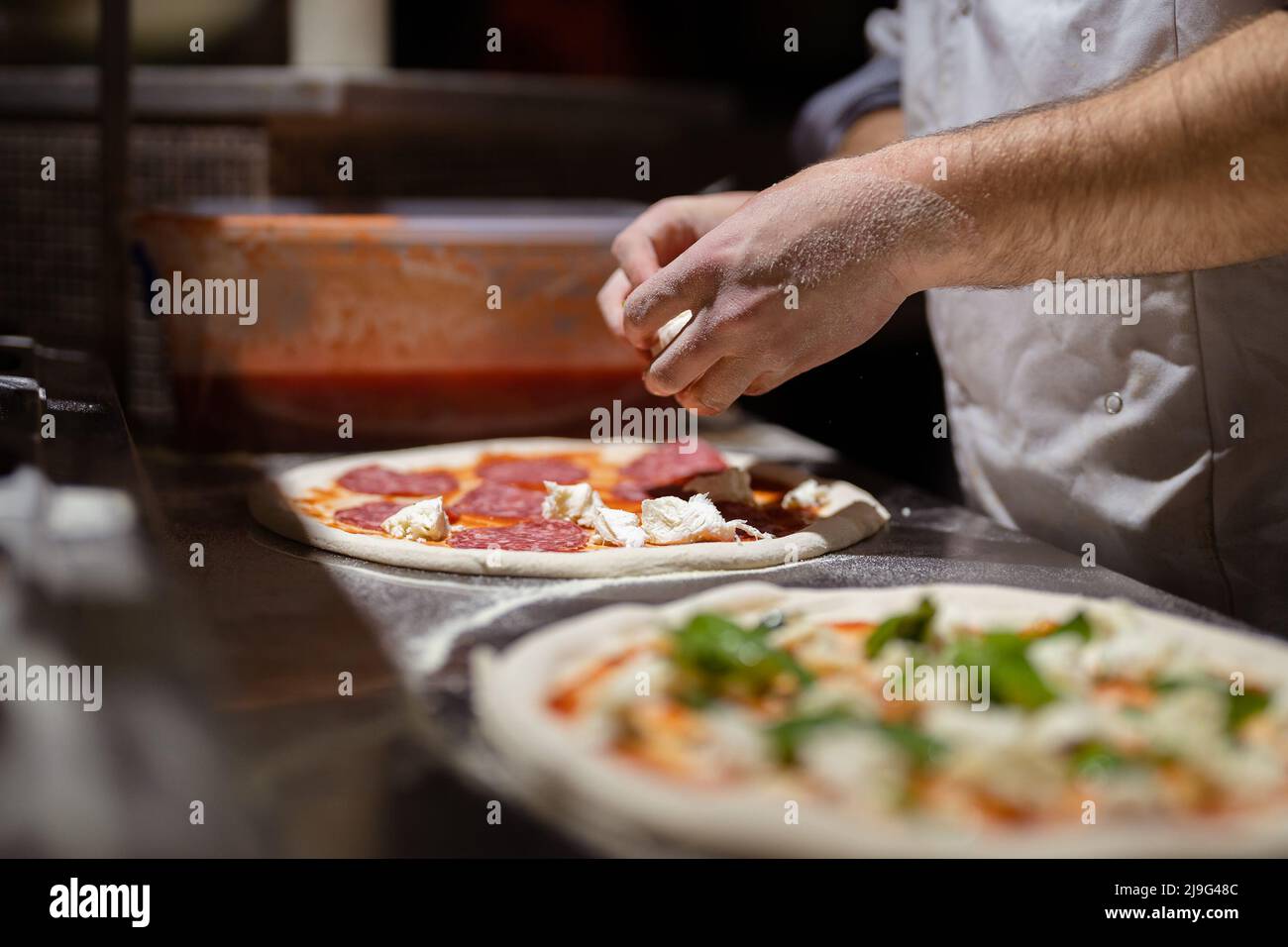 Pizza making process. Male chef hands making authentic pizza in the ...