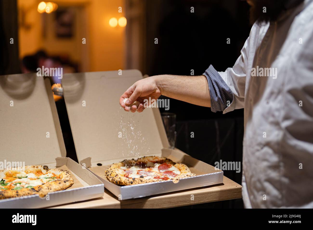 Pizza making process. Male chef hands making authentic pizza in the ...