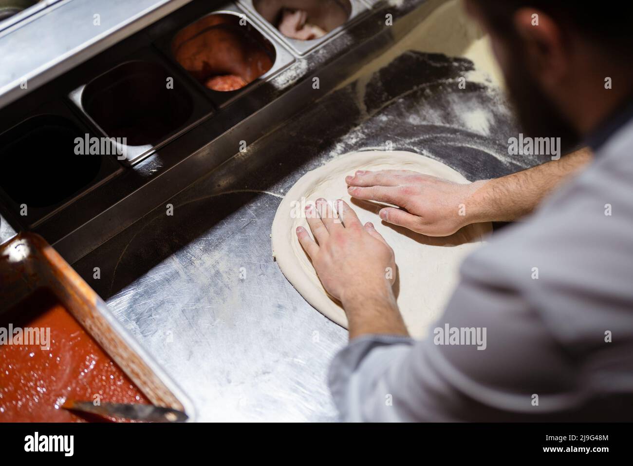 Pizza making process. Male chef hands making authentic pizza in the ...